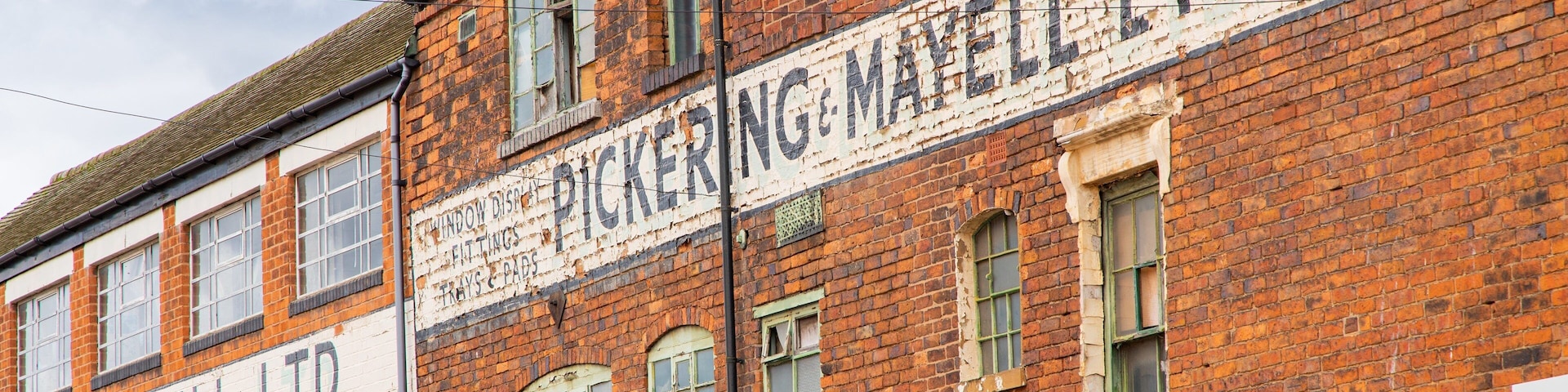 A brick building with signs for 'Pickering & Mayell Ltd.' and 'Cases for Jewellery Silver & Plate'.