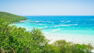 Paisagem costeira com uma praia, águas turquesa cristalinas e barcos.