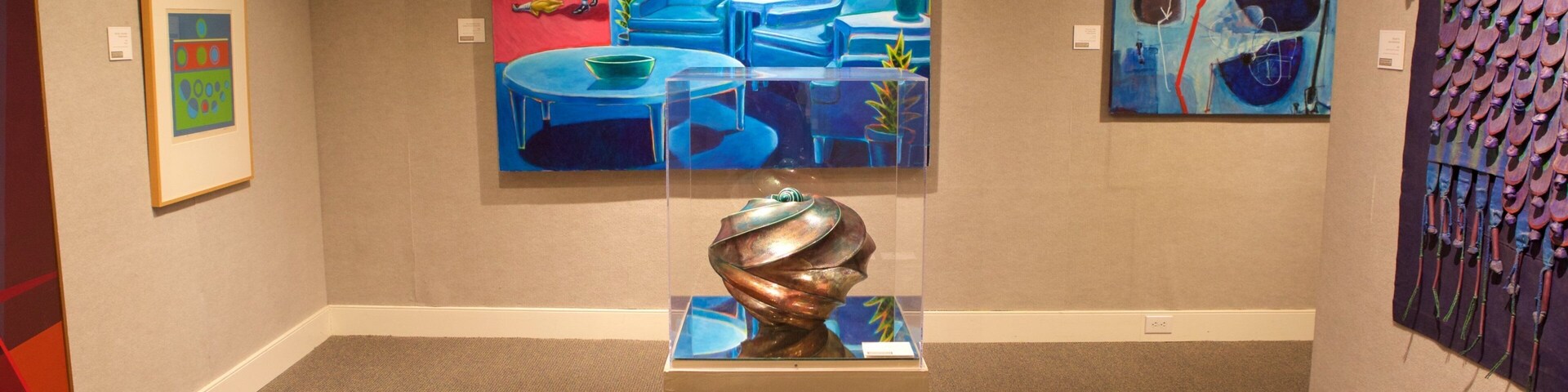 Uma galeria de arte com diversas pinturas e esculturas.