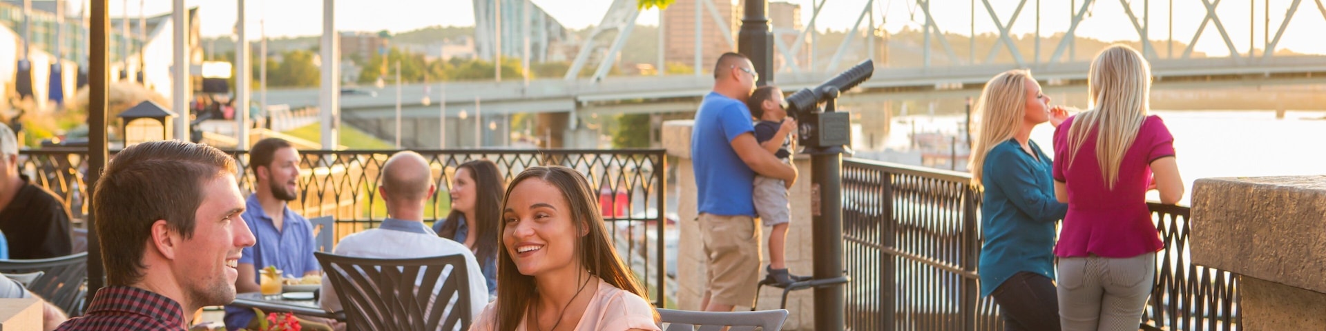 Newport on the Levee featuring outdoor eating as well as a small group of people