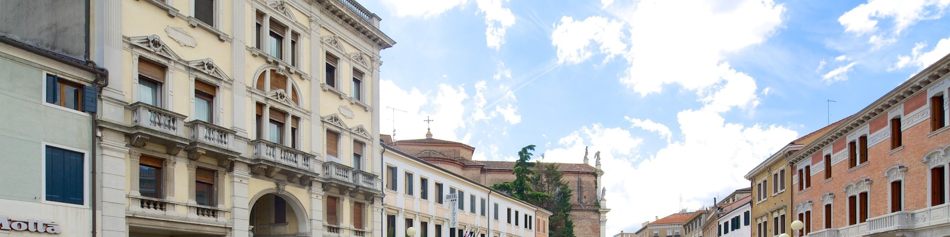 Uma praça histórica com arquitetura clássica, cafés e uma fonte imponente.
