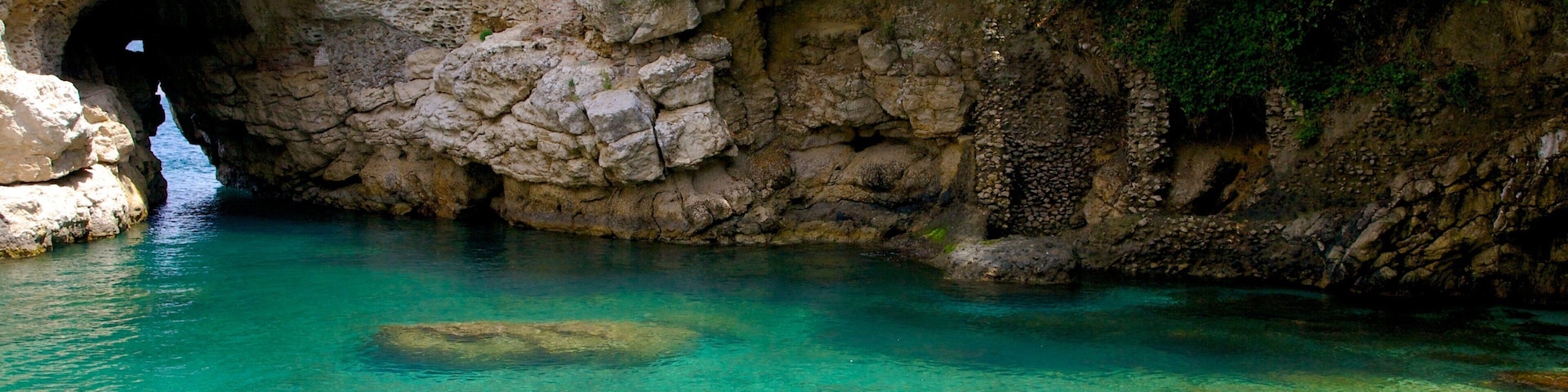 Baths Of Queen Giovanna showing swimming and rocky coastline as well as an individual femail