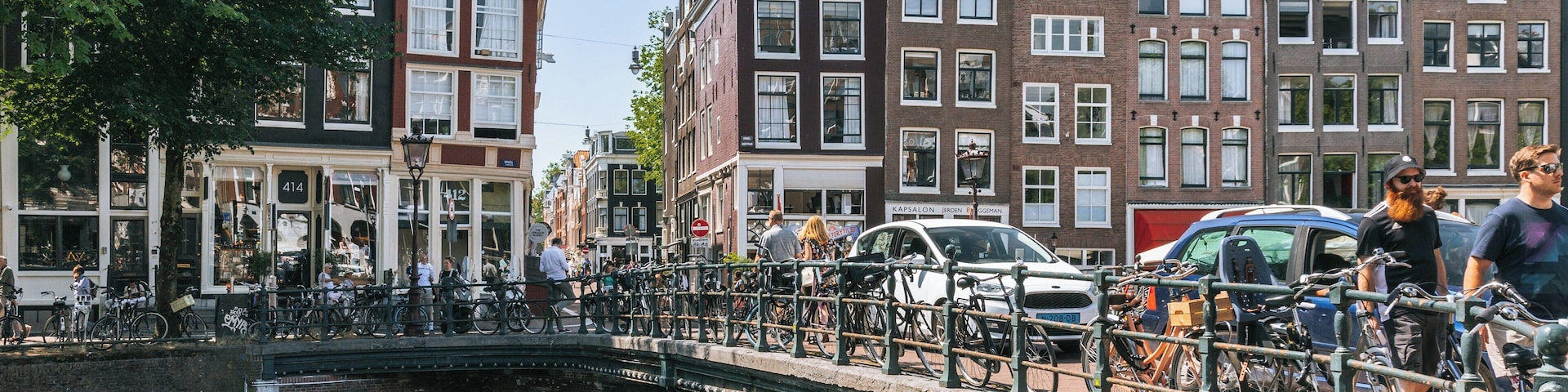 Um canal com uma ponte, edifícios históricos e bicicletas.