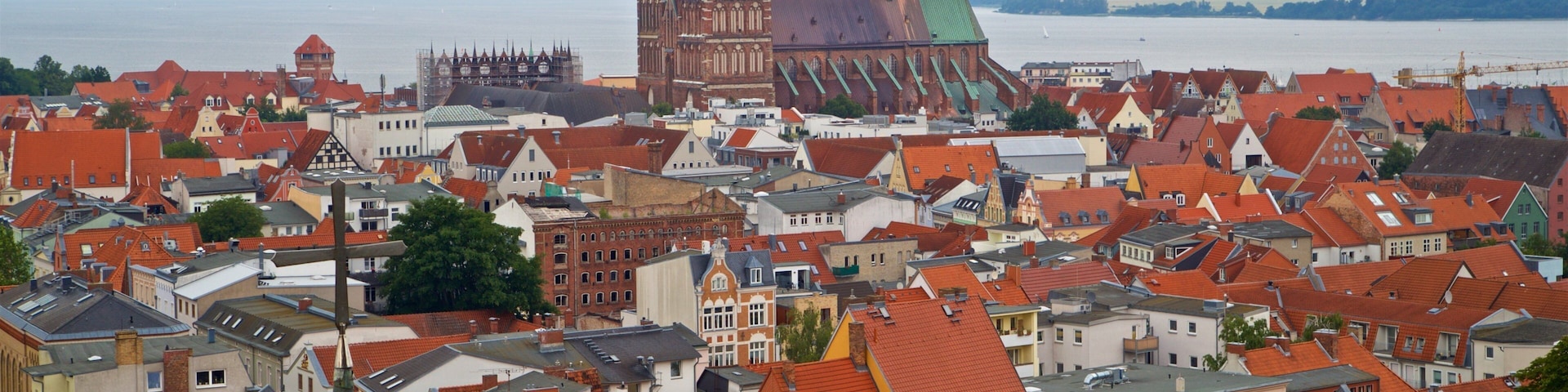Paisagem urbana com edifícios históricos e uma igreja com cúpula verde.