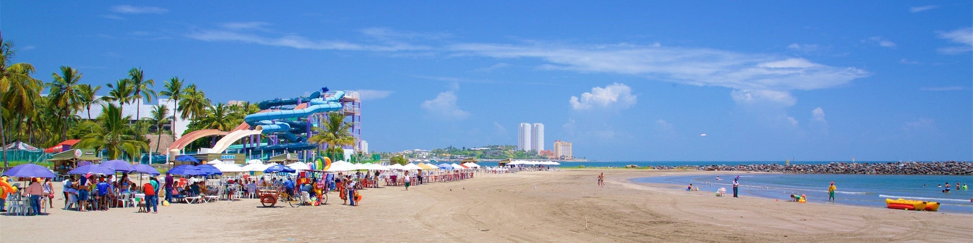 Praia de Mocambo caracterizando uma praia de areia assim como um grande grupo de pessoas