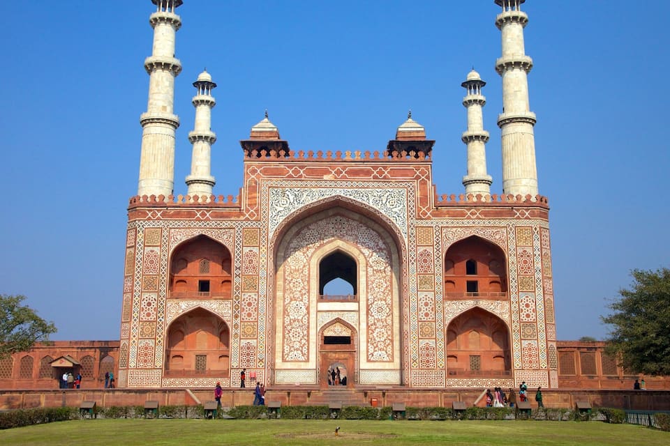 Um edifício grande e ornamentado com quatro minaretes e trabalhos de azulejos detalhados.