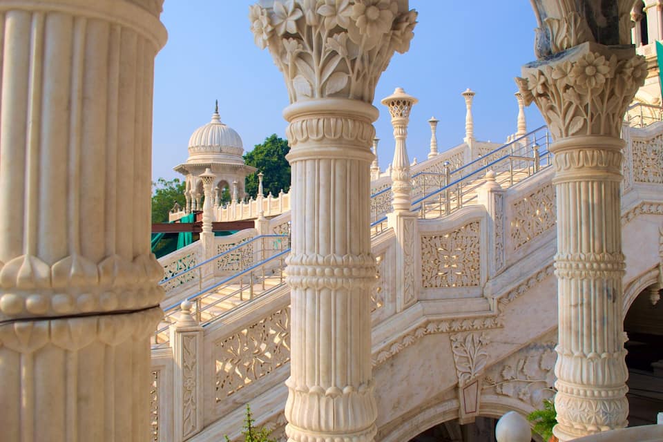 Colunas brancas ornamentadas e uma escadaria imponente com esculturas detalhadas.