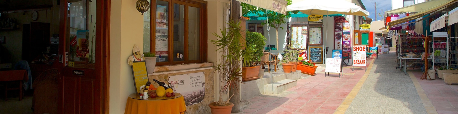 Uma rua com um restaurante chamado Kavacafe, um bazar de sapatos e diversas lojas.