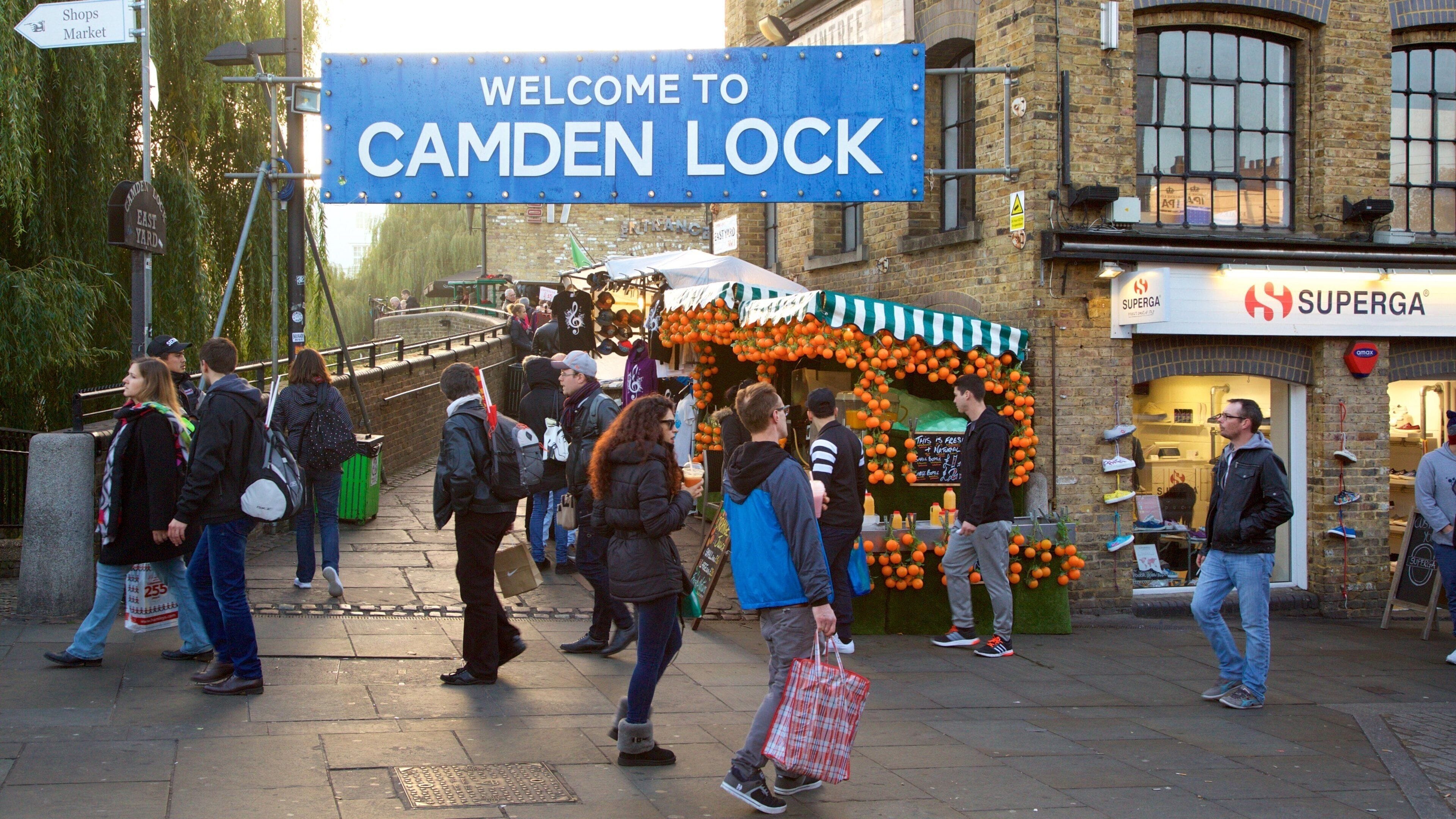 Uma rua movimentada em Camden Lock, com um letreiro chamativo que diz 'Welcome to Camden Lock'.