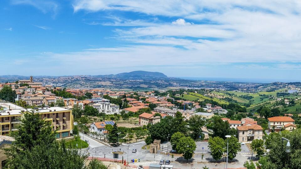 Vista panorâmica de uma cidade com uma colina imponente ao fundo.