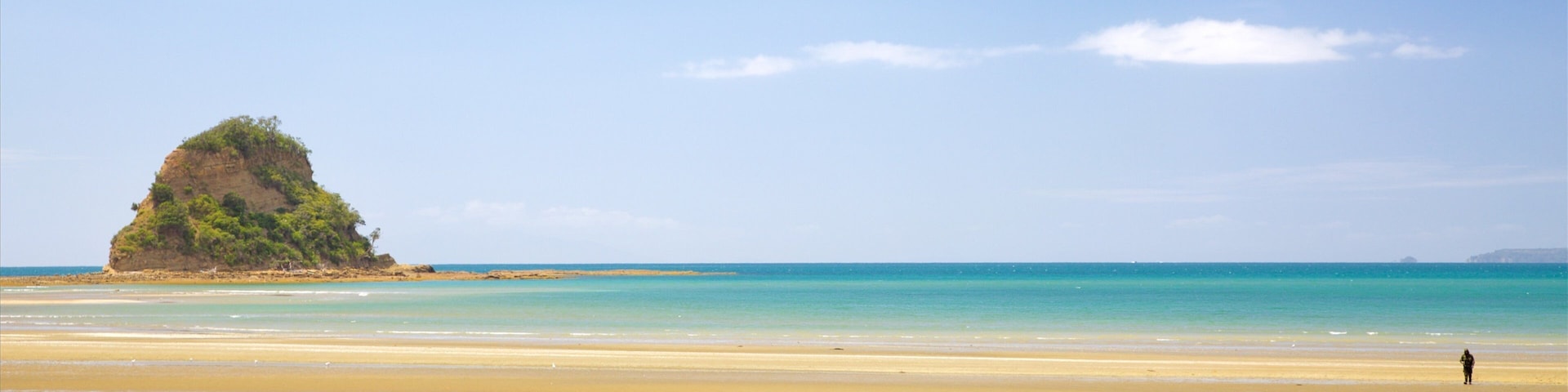 Waiwera mostrando uma praia e uma baía ou porto