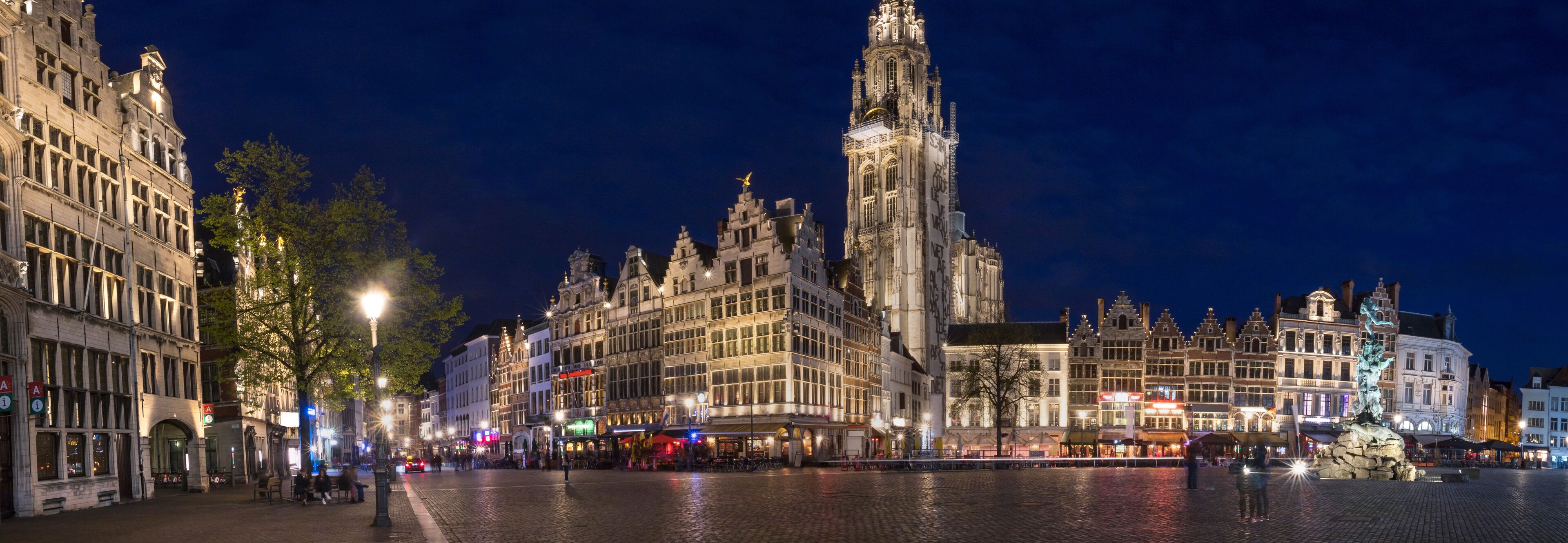 Uma praça histórica com edifícios ricamente decorados e uma torre imponente.