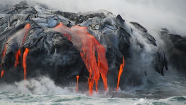 Litoral rochoso com lava escorrendo.