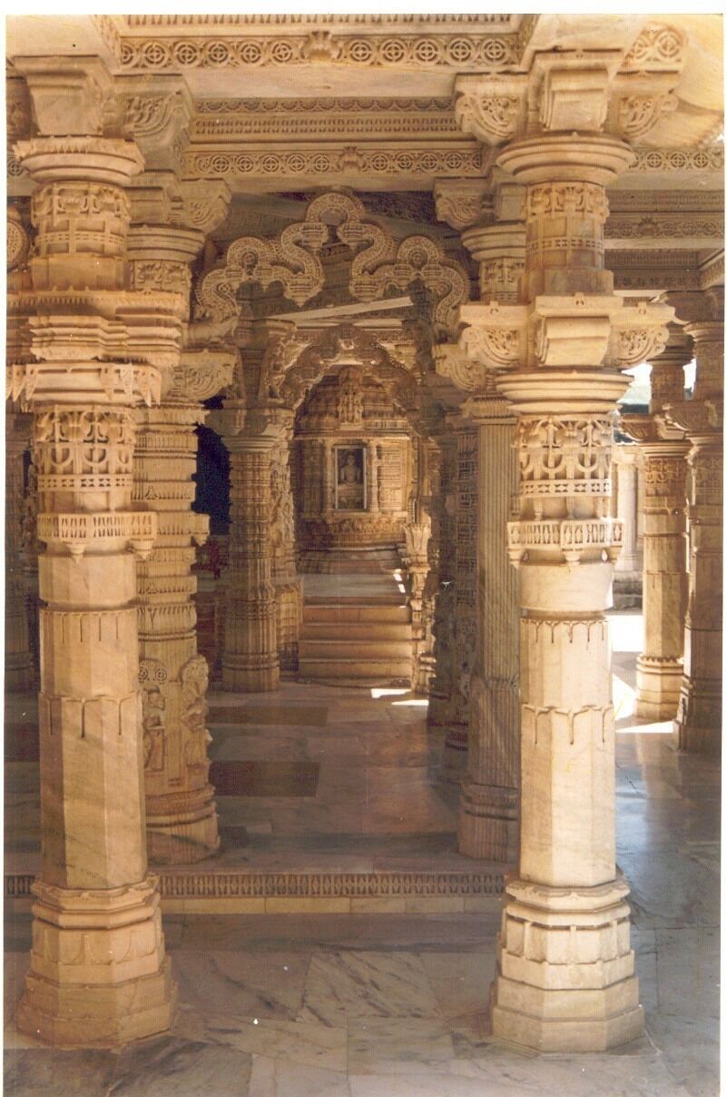 Interior de um templo ornamentado, com esculturas detalhadas em pilares e arcos.