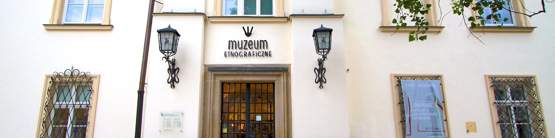 A museum entrance with a sign reading "museum etnograficzne" and a poster advertising an event from 17.05 to 29.09.2013.