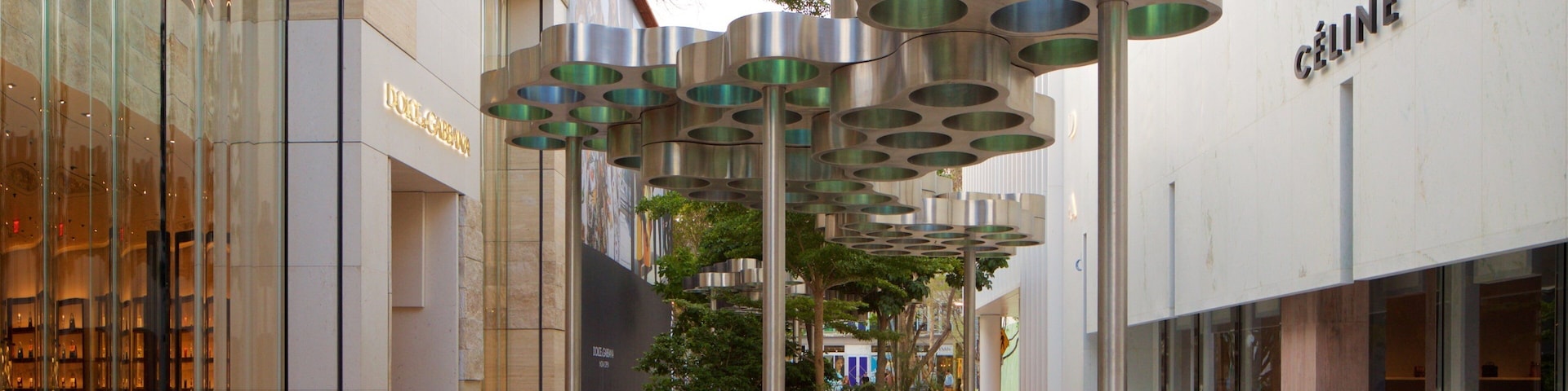 Uma área comercial com arquitetura moderna, incluindo uma loja Dolce & Gabbana e uma loja Céline.