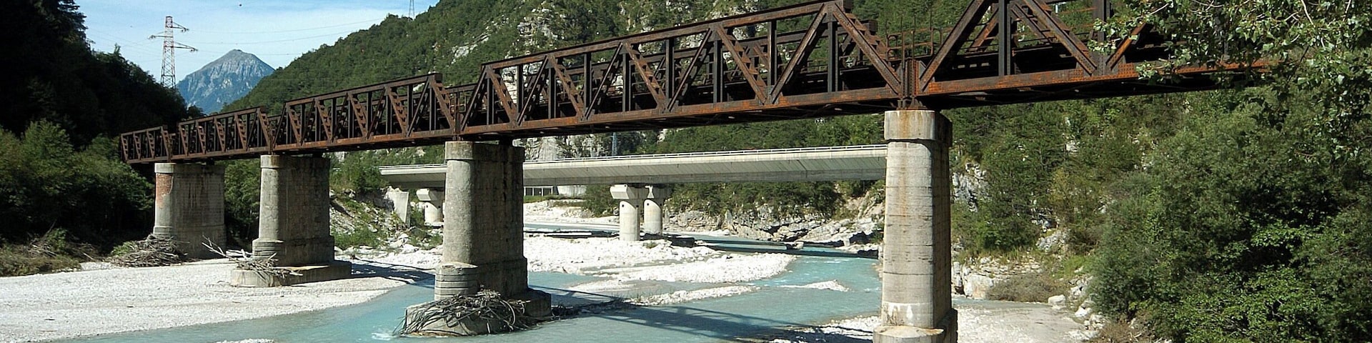 Railroad bridge across the river Fella, part of a defunct railroad line called the old "Pontebbana", in the north-eastern part of Italy, region Friuli Venezia-Giulia. In the background there are the two bridges of the Autostrada Alpe-Adria.