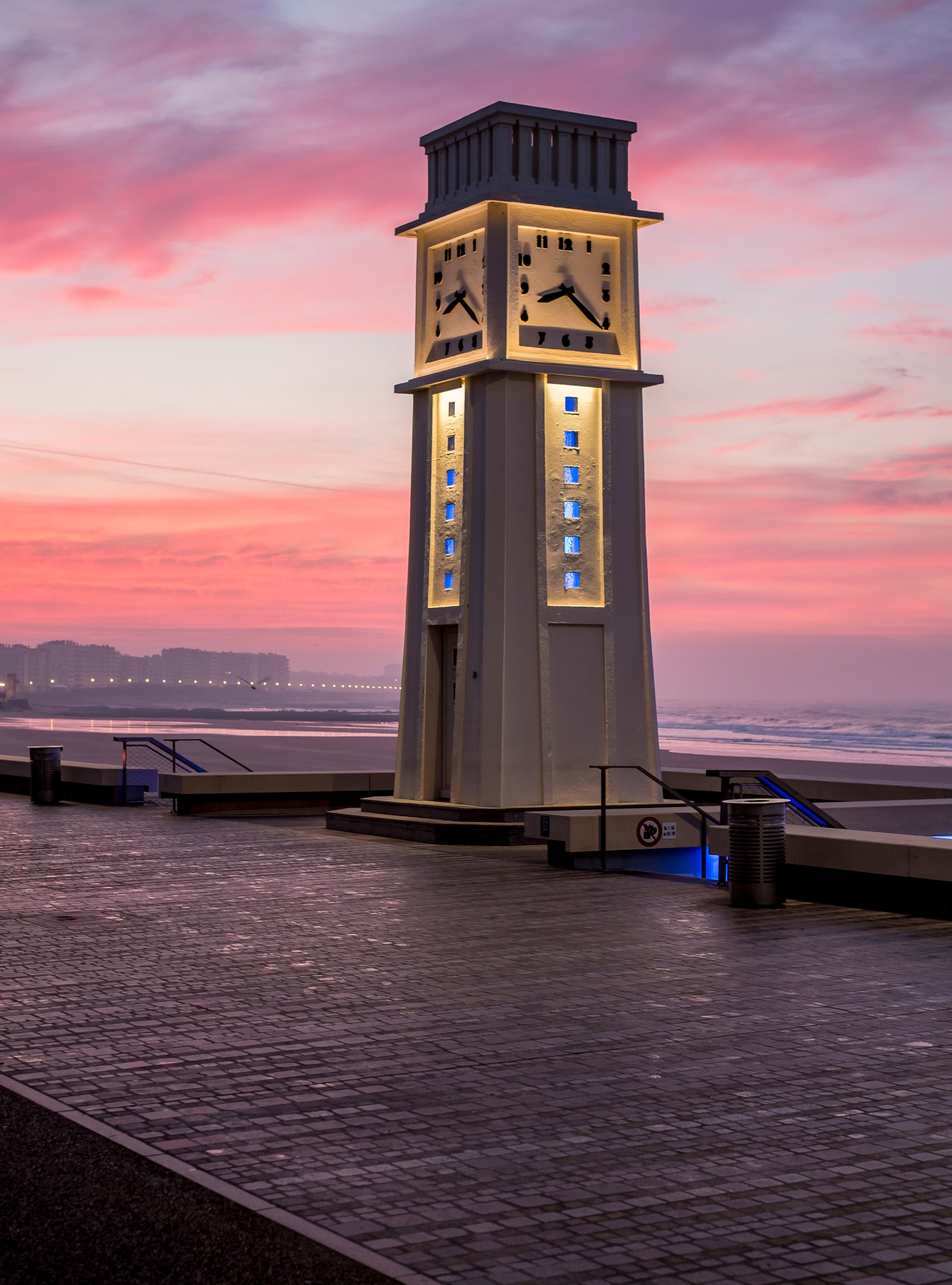 Um relógio com números iluminados ao pôr do sol.