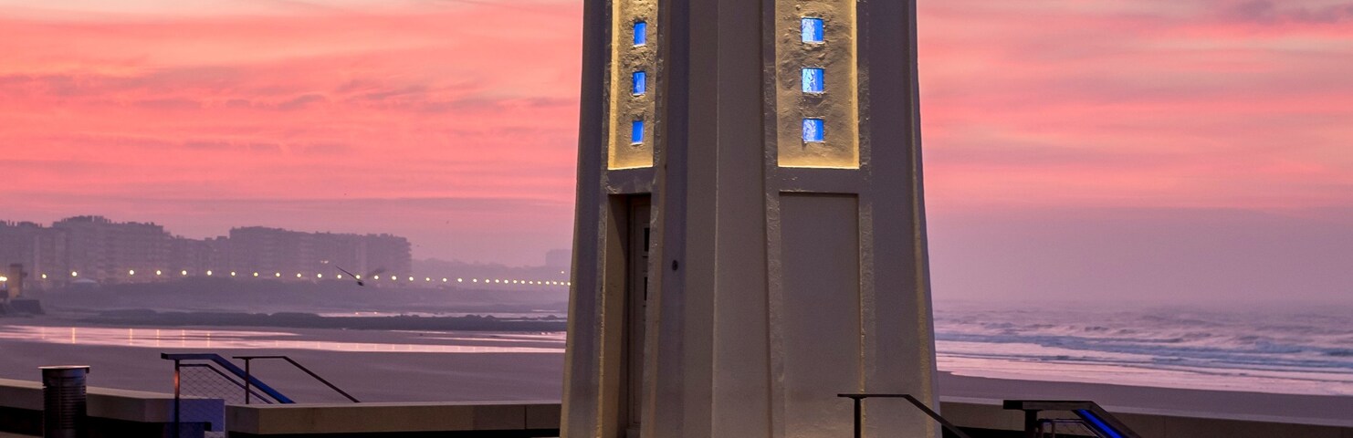 Um relógio com números iluminados ao pôr do sol.
