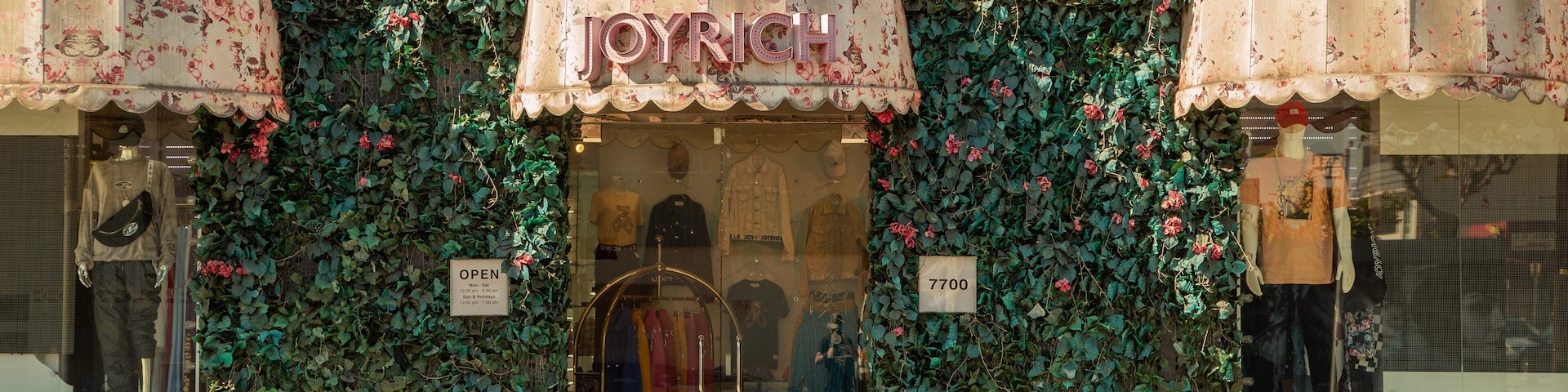 Fachada de loja com uma placa indicando "JOYRICH" e o número "7700" na parede.