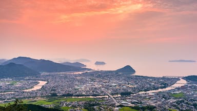 Paisagem urbana com rio, montanhas e uma ponte.