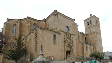 Uma igreja histórica com uma torre de sino e uma grande entrada em arco.
