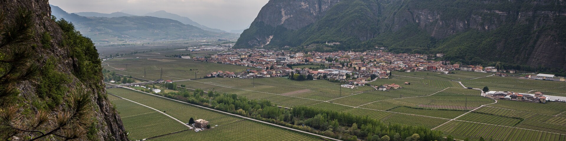 Um vale com campos em socalcos, uma cidade e montanhas.