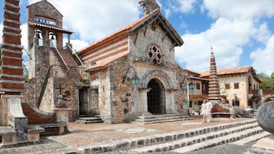 Uma igreja antiga com uma torre de sino, fachada de pedra e uma grande entrada em arco.