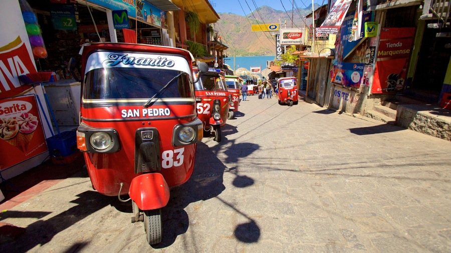 Um tuk-tuk vermelho com o número 83 estacionado na rua.