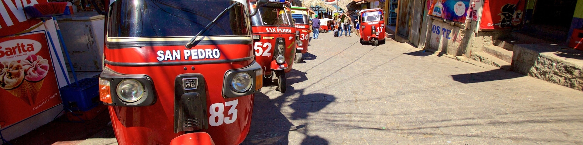 Um tuk-tuk vermelho com o número 83 estacionado na rua.