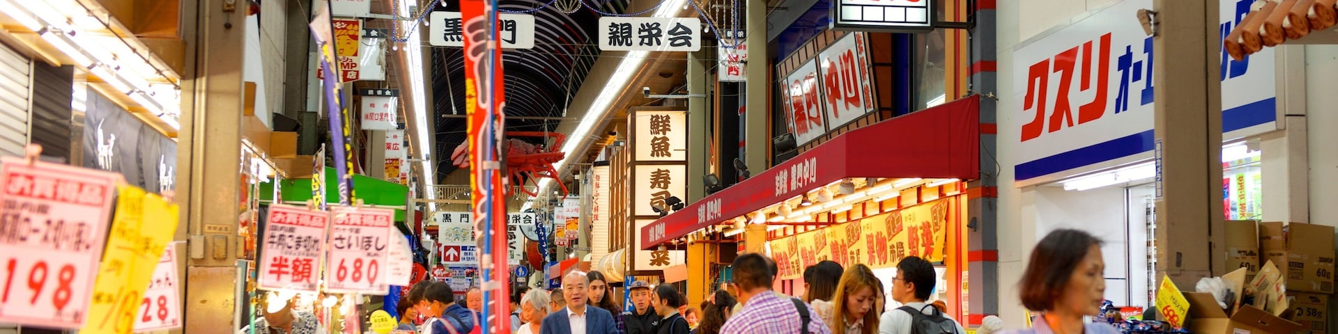 Kuromon Ichiba Market which includes a city and interior views as well as a large group of people