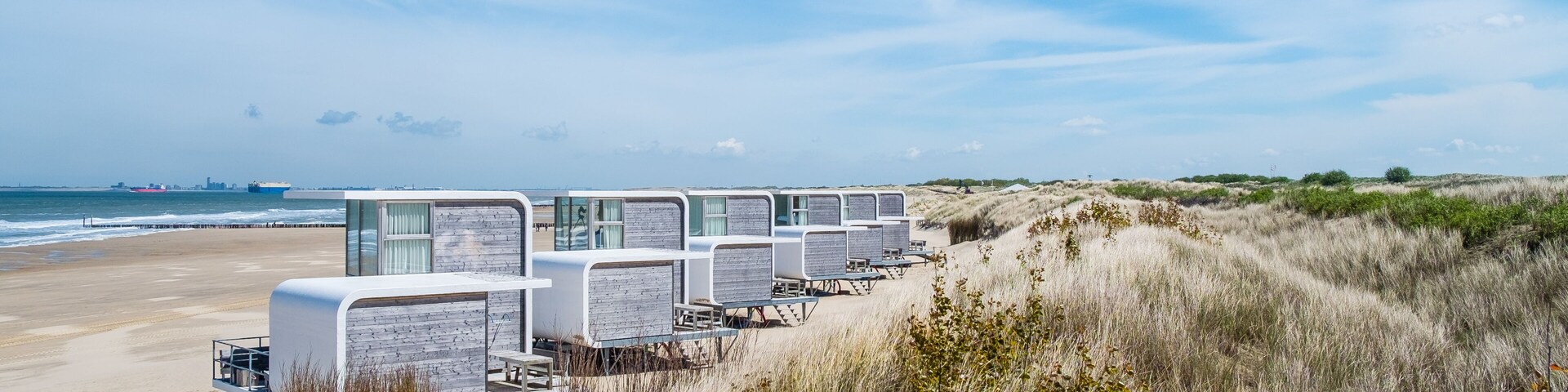 Casas móveis à beira-mar, com vista para o oceano e dunas.