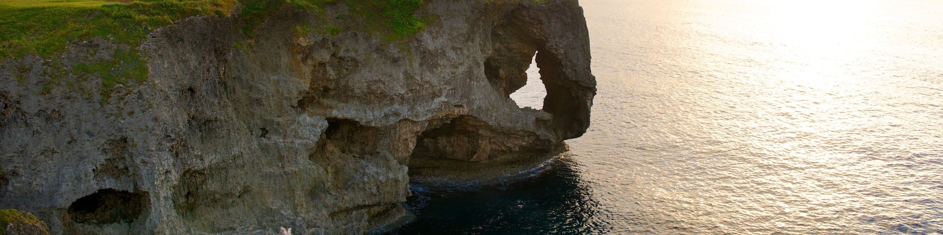 Cape Manza which includes rugged coastline and a sunset