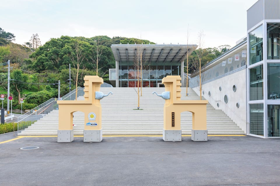 Um edifício moderno com uma escadaria que leva a uma entrada de vidro.