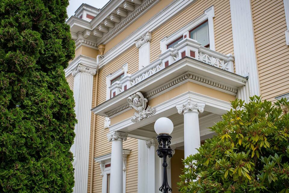 Um edifício clássico com colunas ricamente decoradas e uma varanda.