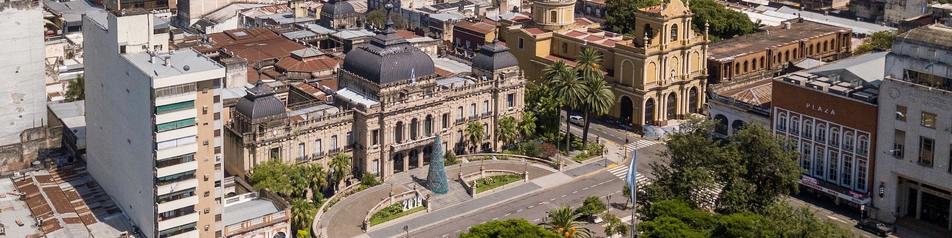 Paisagem urbana com uma catedral imponente, uma praça e edifícios densos.