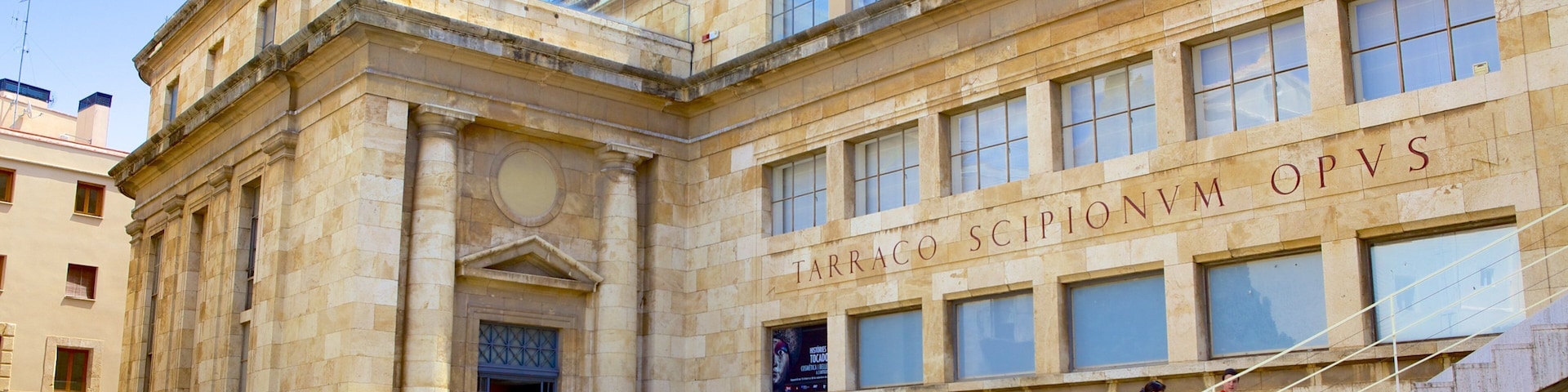 Um edifício histórico com arquitetura clássica, apresentando uma entrada imponente e uma escadaria que leva aos andares superiores.