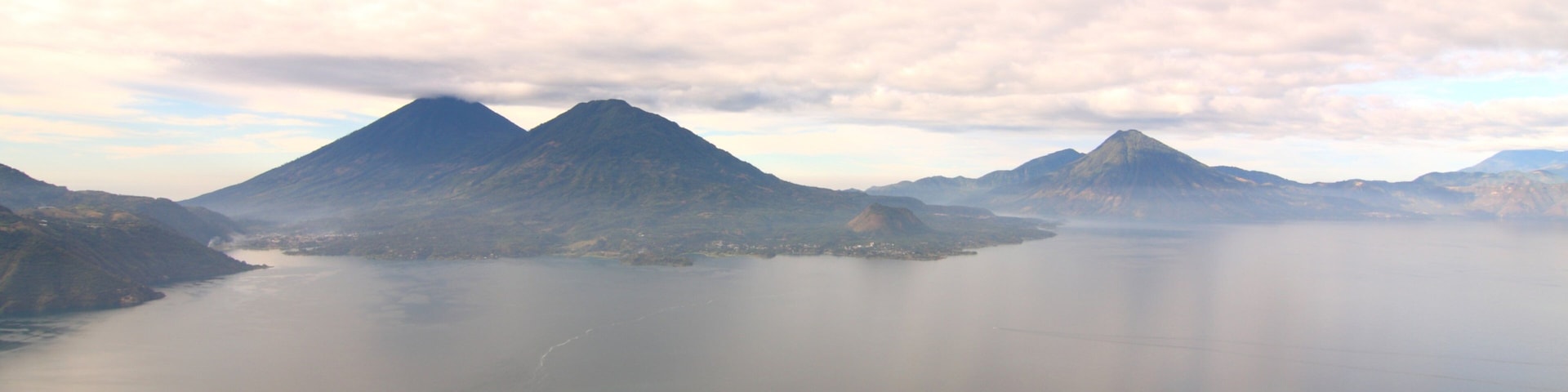 Um lago rodeado por montanhas sob um céu nublado.