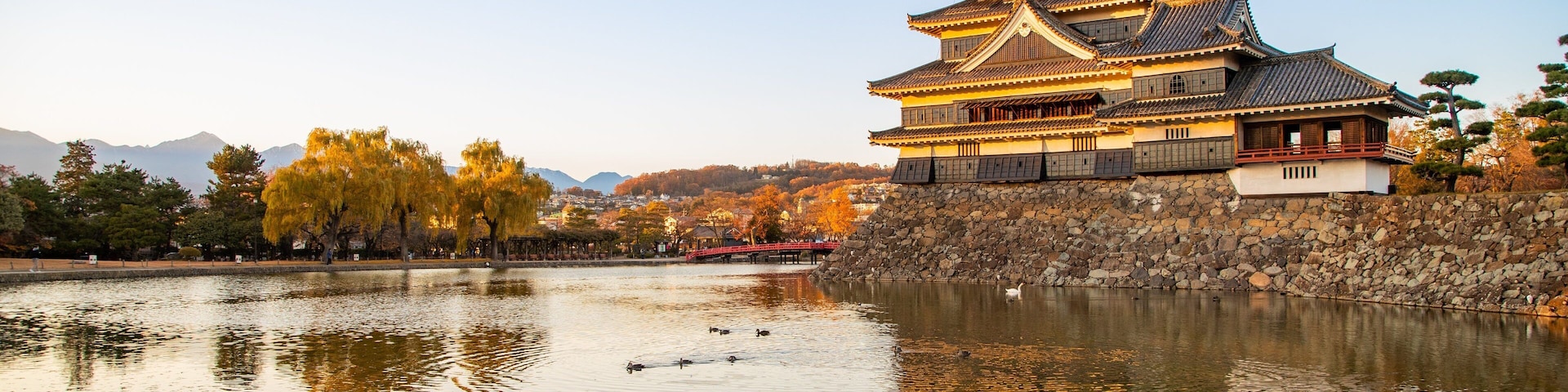 Matsumoto Castle featuring a pond, heritage architecture and a sunset