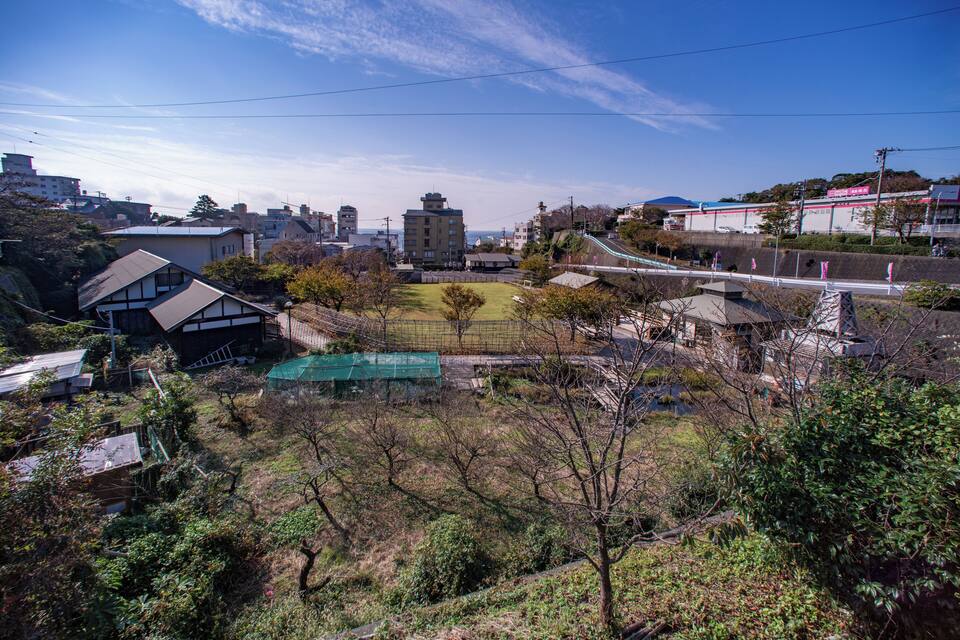 Um bairro residencial com casas, um campo verde e uma montanha ao longe.