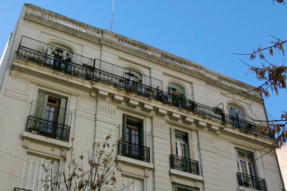 Um edifício com várias andares, varandas e janelas.