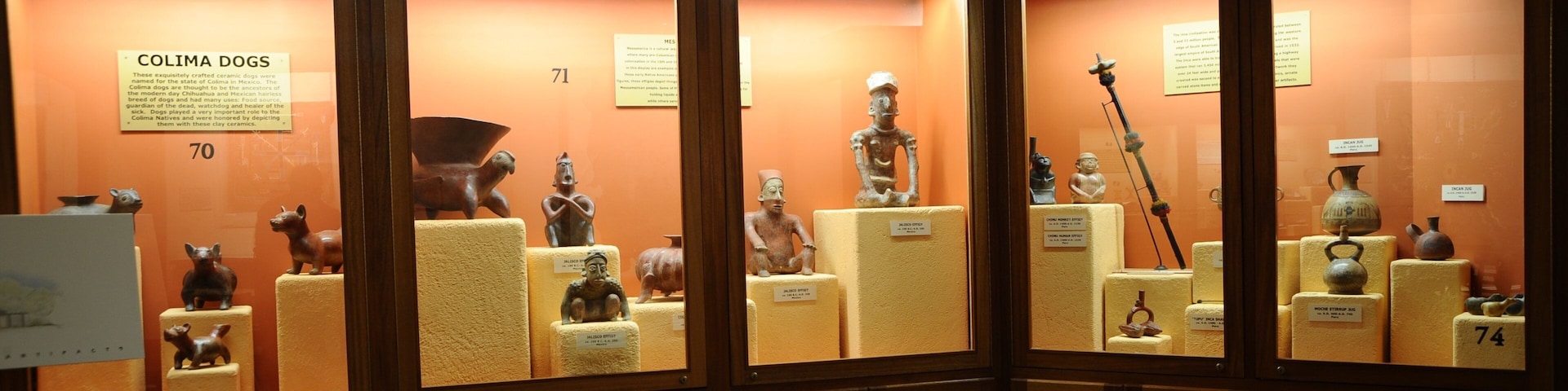 Exposição de cães de cerâmica antigos e vasos de barro.