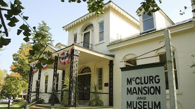 A Mansão e Museu McClurg com fachada branca, varanda frontal e uma placa.
