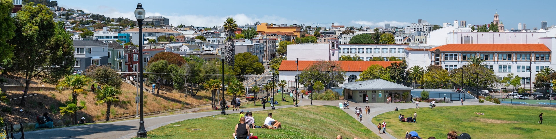 Mission Dolores Park showing picnicing and a park as well as a small group of people