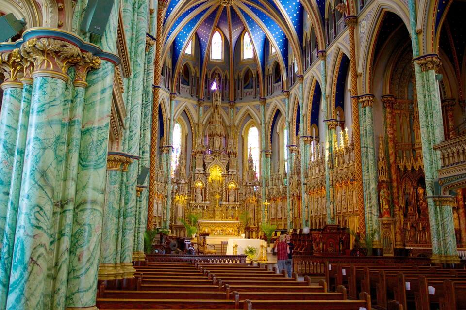 Interior de igreja ornamentado, com colunas de mármore, tetos abobadados e um altar central.