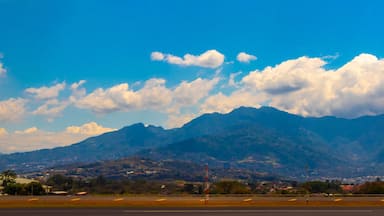 Paisagem montanhosa sob um céu limpo, com uma pista de pouso em primeiro plano.