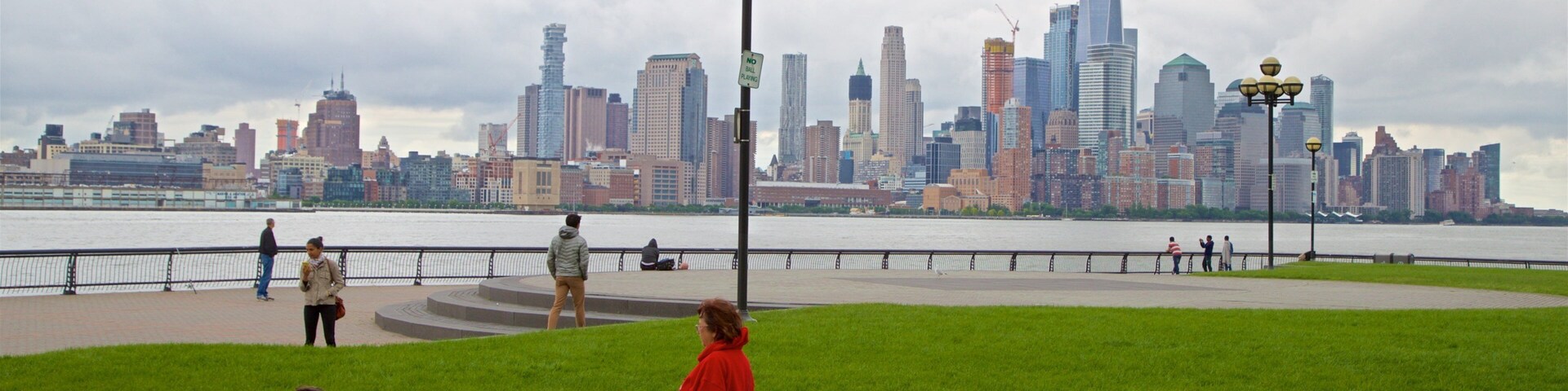 Um parque à beira-mar com o horizonte da cidade ao fundo.
