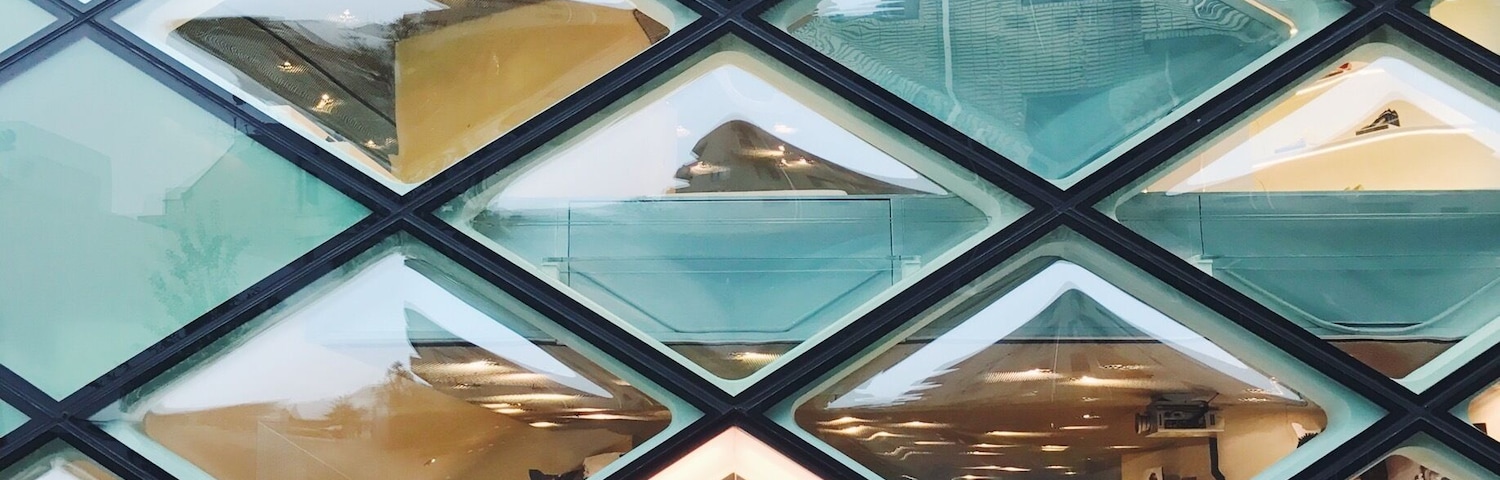 Um edifício moderno com fachada de vidro geométrica.