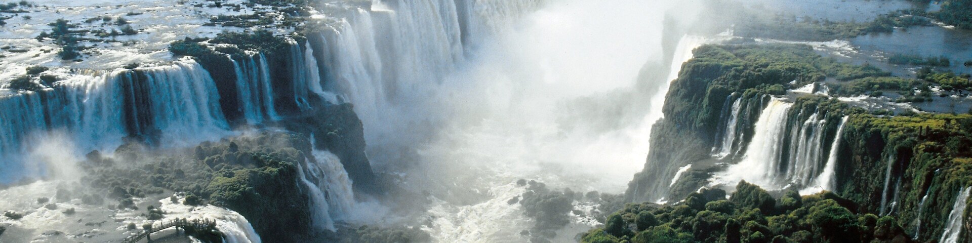 Uma cachoeira imponente com diversas quedas d'água, cercada por vegetação densa.