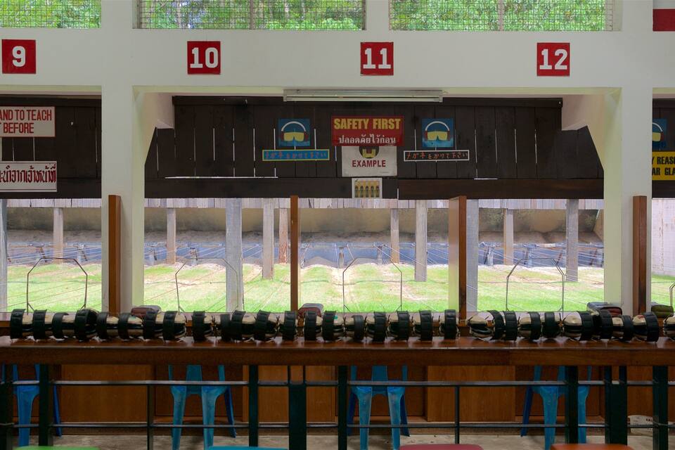 Um campo de tiro com pistas numeradas e placas de segurança.